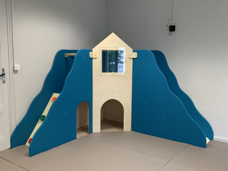 Structure de motricité bois et mousse avec toboggan, escalade, et cabane